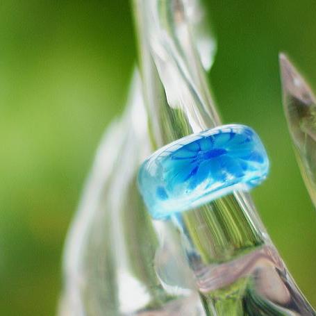 RING優しげな大輪のブルーガーベラが微笑みます。『Blue Gerbera 〜 夏空に咲く花 〜』青空に向かって咲く、美しいブルー色の花・・・。それは優しく咲くガーベラ。重なり合ったブルーの細長い花弁をイメージしてリングの内部に施しました...