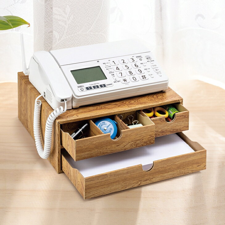 FAX周りをすっきり整理！木目調卓上FAX台 散らかりやすいFAX周りの小物をすっきり整理できる、便利な木目調卓上FAX台です。軽くて丈夫な強化段ボール製ながら、耐荷重は約15kgとしっかりした作り。ハサミなどの長物から、ペンやクリップなど...