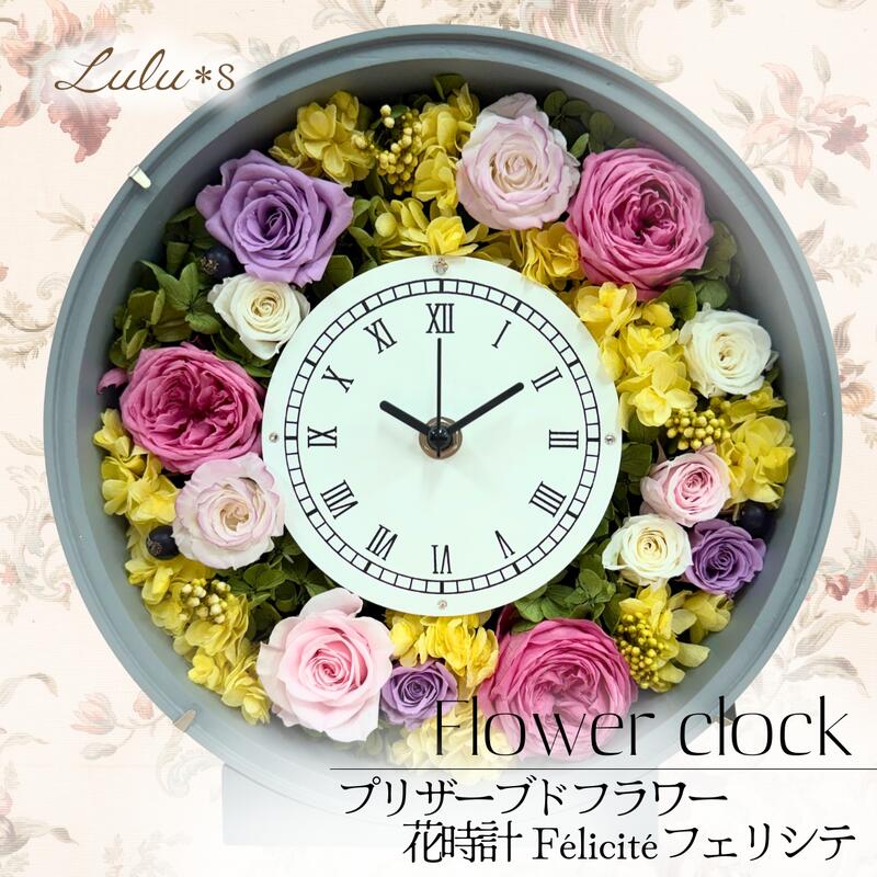 花と時間が調和する、上品なインテリア。 プリザーブドフラワー花時計「Félicité（フェリシテ）」 「最高の幸せ」を意味するフェリシテ。落ち着いたグレーの円形フレームに、ピンクやパープルの美しいローズを贅沢に敷き詰めたエレガントな花時計で...