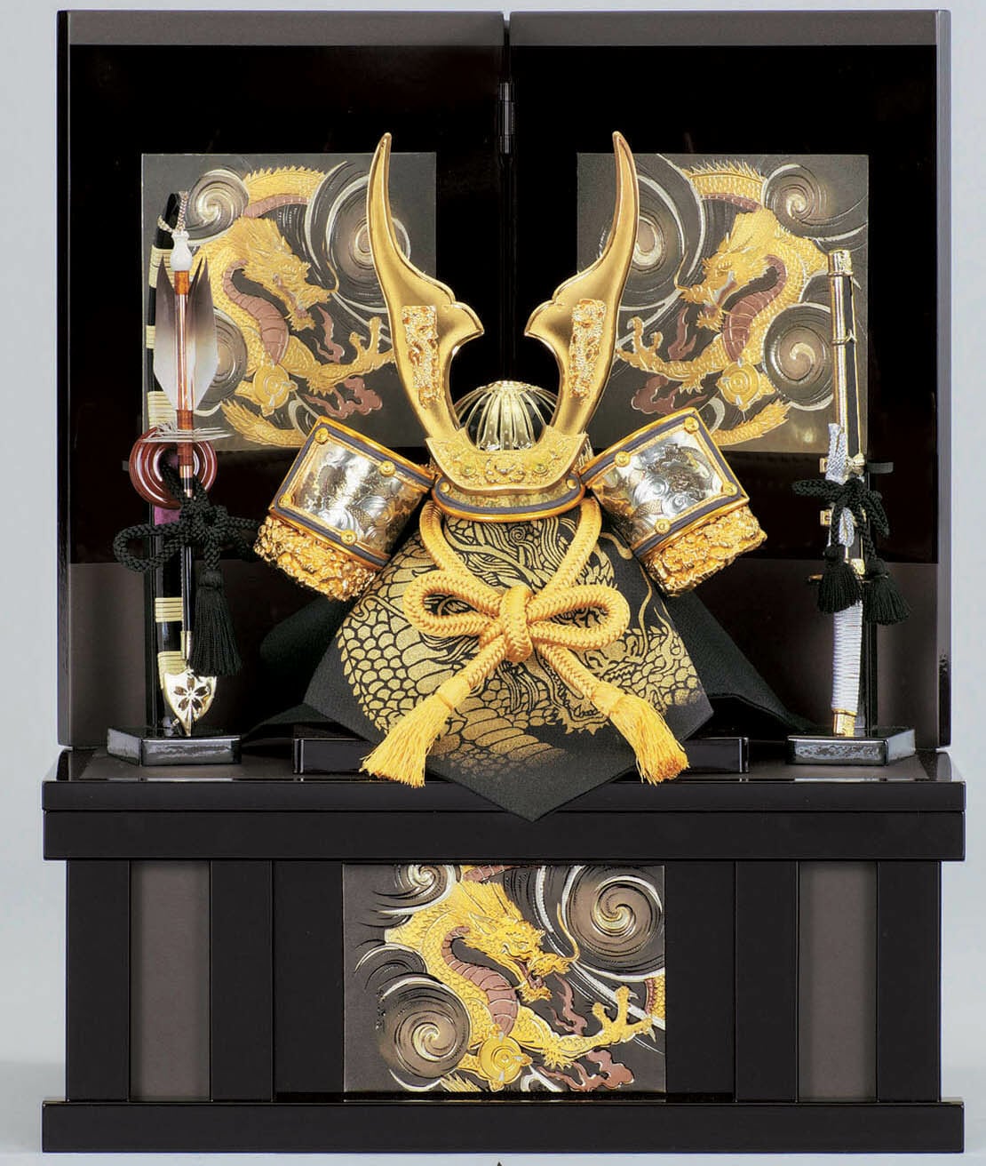 詳細 飾り台の中に兜、御道具を収納できるワンパッケージタイプ。飾り台と屏風の豪華な彫金が人気のシリーズです。 SIZE　間口38×奥行31×高さ48 【付属品】　五月人形の飾り方冊子・お手入れセット（白手袋・天然毛バタキ・クロス）・オルゴー...