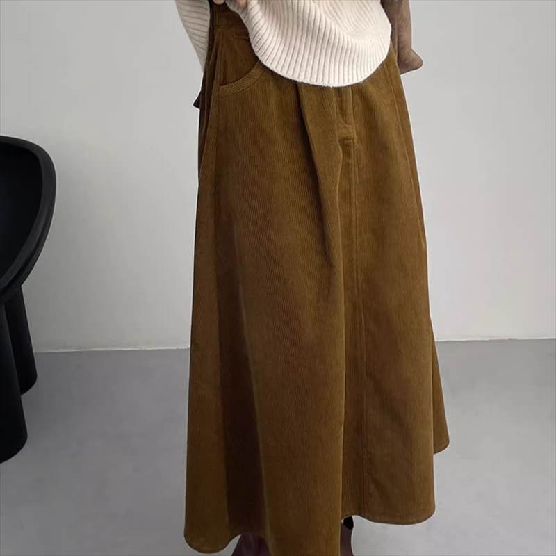 おしゃれに決まる、コーデュロイ ロング スカートのご紹介です！秋冬にぴったりなセミフレアの台形デザインで、体型カバーも実現します。ウエストはゴム仕様で楽ちん、さらに便利なポケット付きで日常使いにも最適！上品なブラックとブラウンの2色展開で、...