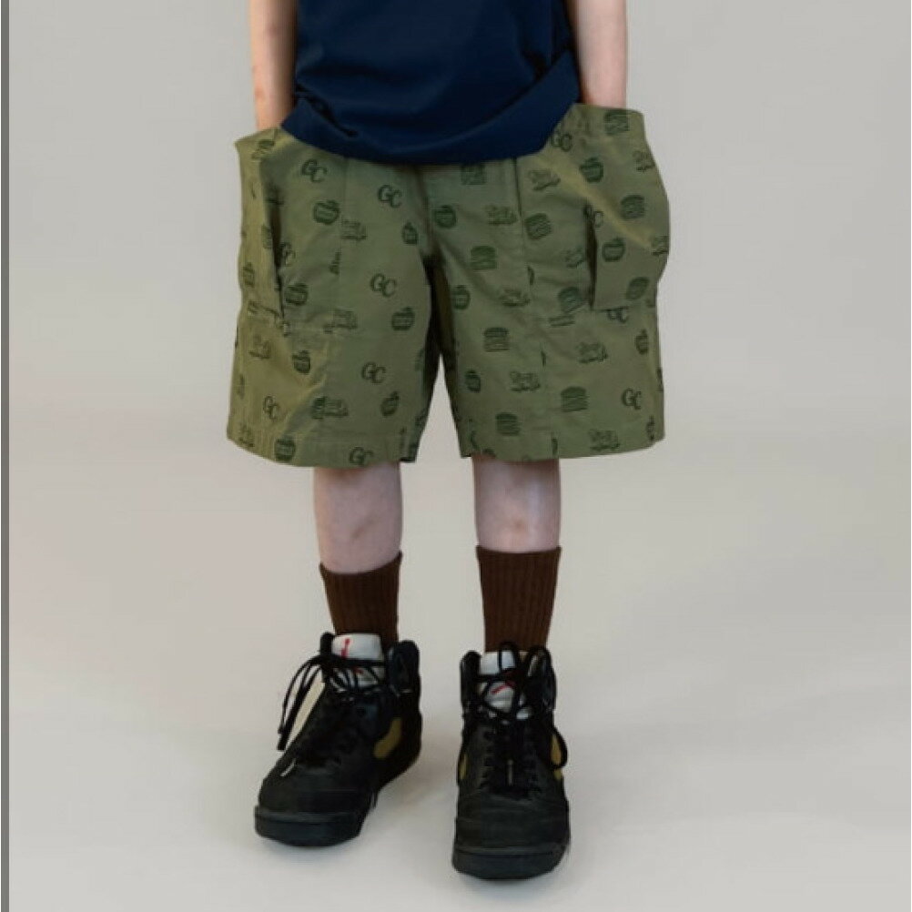 “グルーヴィーカラーズ”のGC ソウガラ サイドポケット SPN【3月入荷予定】・ブランドアイコンのハンバーガーやリンゴにロゴを合わせた総柄・少しルーズな膝下丈のショートパンツ・ハリのあるコットン100％ダンプ素材・大きな左右のポケットがポ...