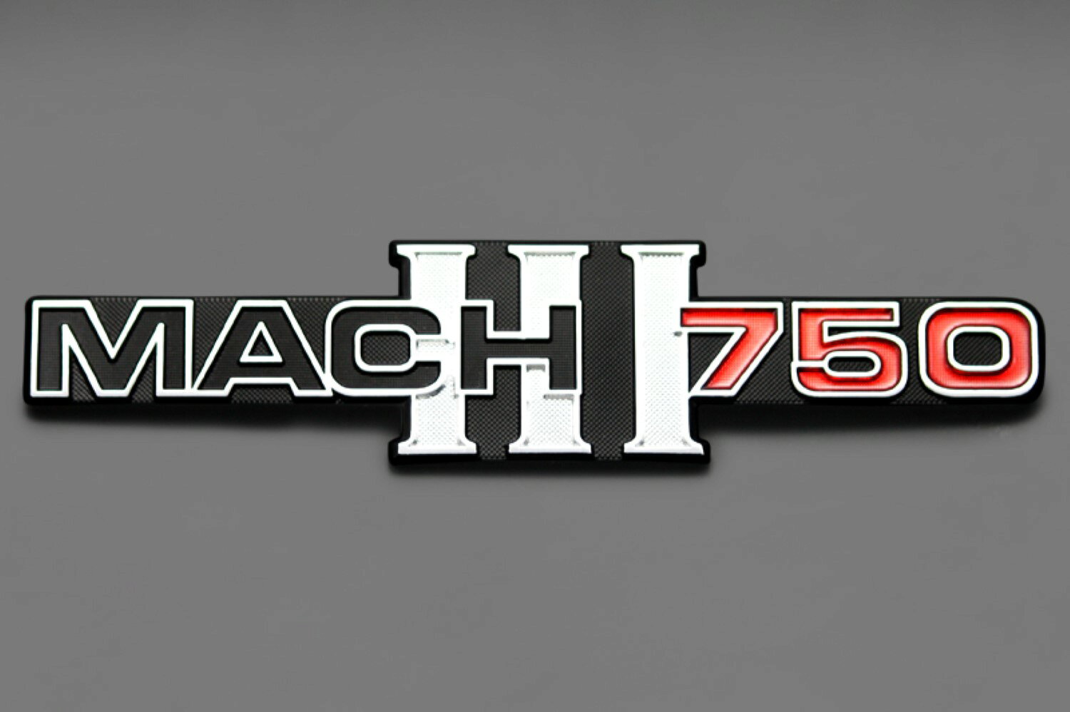 "MACH"の文字を冠するアルミダイカスト製サイドカバーエンブレム。