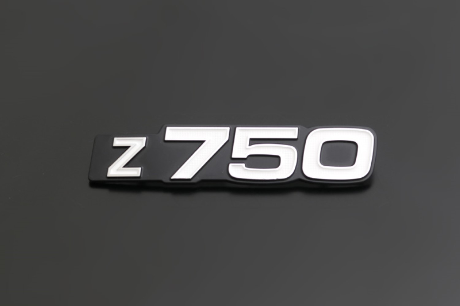 76〜'78 Z750A4/A5,Z750D1用の"Z750"サイドカバーエンブレム。取付用スピードナット2枚付属します。取付ピッチ74mm。左右共通 1枚単位でのデリバリー。