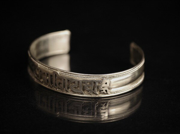 観音真言 銀製腕輪 材質　銀製 16.5cm×1.3cm　フリーサイズ 本作品は、銀製腕輪（バングル・ブレスレット）です。 オーソドックスな身幅のシルエット。 観音真言デザインです。 ※サイズはおおよその目安となります。 ※微細な擦れや、お...