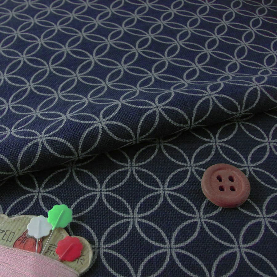 ムラ糸で織った藍染め調の布に、シンプルな伝統柄を染め上げた和柄コットン生地。かすり風の線がプリントされた地は、素朴でやさしい風合い。エプロンやのれん、シャツなどに。単色でシンプルな柄を生かし、男性の小物などにもいかがでしょうか。●円を連ねた...