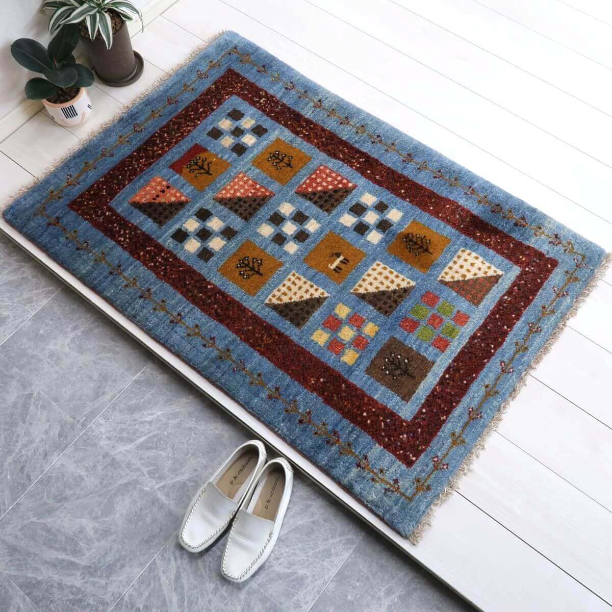 BS-11489 118×81cm 写真で表示（読み方例：1567＝15.67ミリ） イラン・シラーズ ウール ラティーフ手織り 無料 この絨毯には、明るい青の背景に対し、橙、茶色、白、黒のチェック柄が映えています。 それぞれには、小さな木...