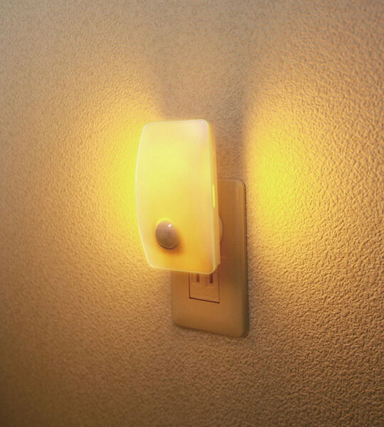 LEDナイトライト 明暗人感センサー アンバー ●直接コンセントに差し込むだけですぐにご使用いただけます。●暗い時にセンサーが人を検知すると自動で点灯し、約2分後に自動で消灯します。●発光面全体が、ほのかにひかり足元を照らします。●プラグ部...