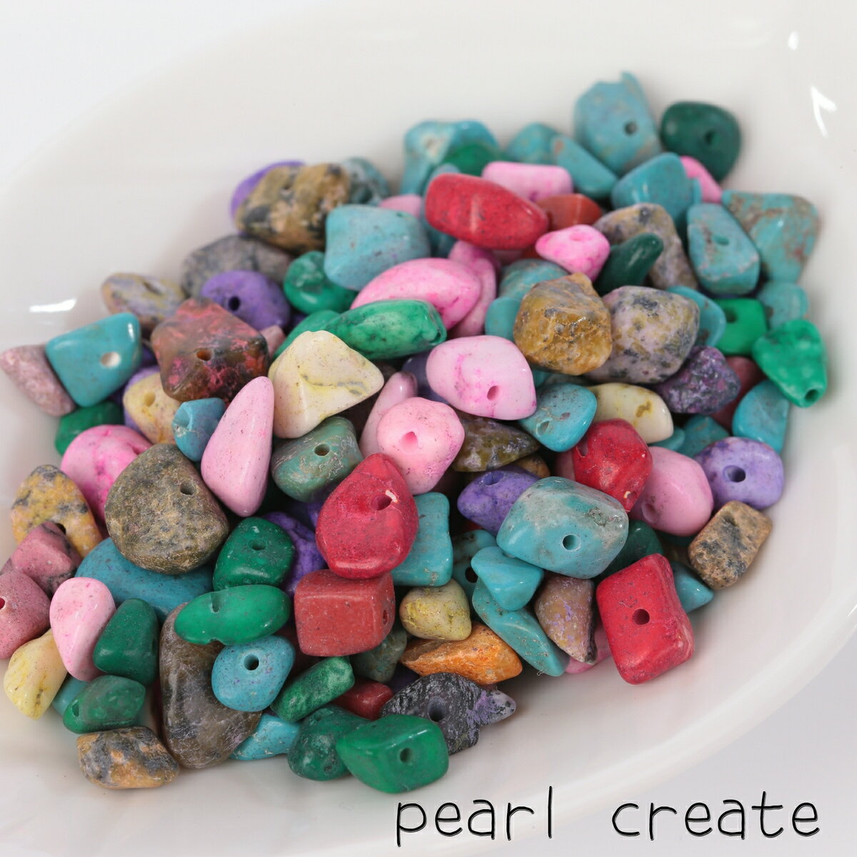ナチュラルな風合いとカラフルな彩りが特徴の、天然の小石に穴を開けて加工した小石ビーズ。 アジアンな雰囲気の色合いが魅力で、エスニック＆個性的なアクセサリー作りにおすすめの天然石パーツです。 カラーやサイズはランダムにミックスされており、天然...