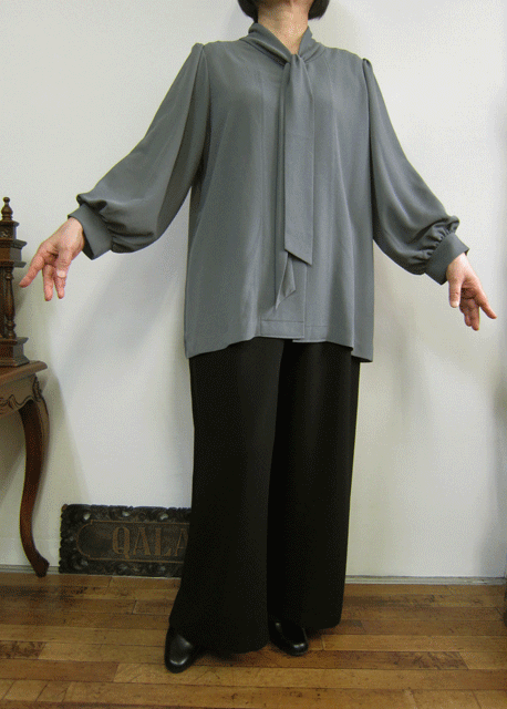 ポリジョーゼットのふんわり素材を活かした ショール衿ブラウスが登場！ 自由自在に楽しめるショール衿は 貴方の気分を表現できそう♪ 初対面の方には蝶結びでガード。 会話が進めばゆらりと解きます。 そろそろ帰ろうの合図は小さく結ぶ。 袖口のギャ...