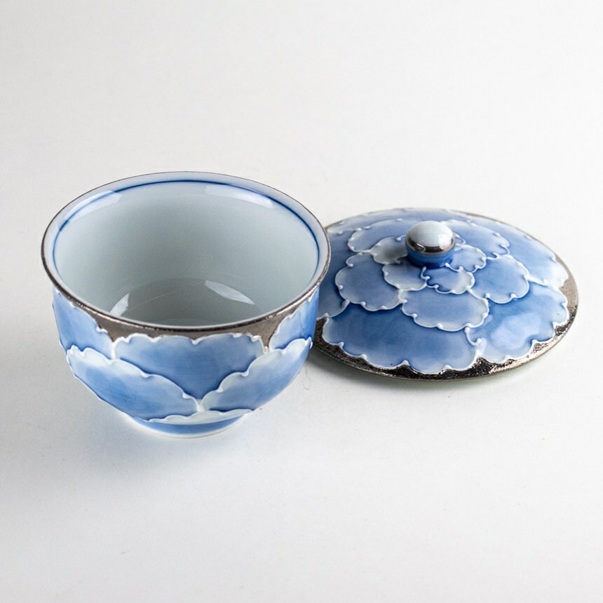 【サイズ】（蓋付）径9cm×高さ8cm　（碗のみ）径8.2cm×高さ5.7cm ◇材質：磁器 ◇生産地：日本（有田焼） 淡い藍色の牡丹文様に、白抜きとプラチナ彩が美しく調和した蓋付き汲出しです。 一珍技法によって立体的に描かれた花びらが、光...