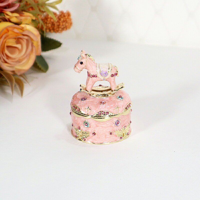 木馬をモチーフにした、メルヘンなミニジュエリーボックス。 ピンクベースの上品な配色に、ゴールドの縁取りと、きらりと輝くラインストーンがあしらわれたエレガントで可憐なデザインです。フタを開けるとリングやピアスなど、小さなアクセサリーを入れるこ...