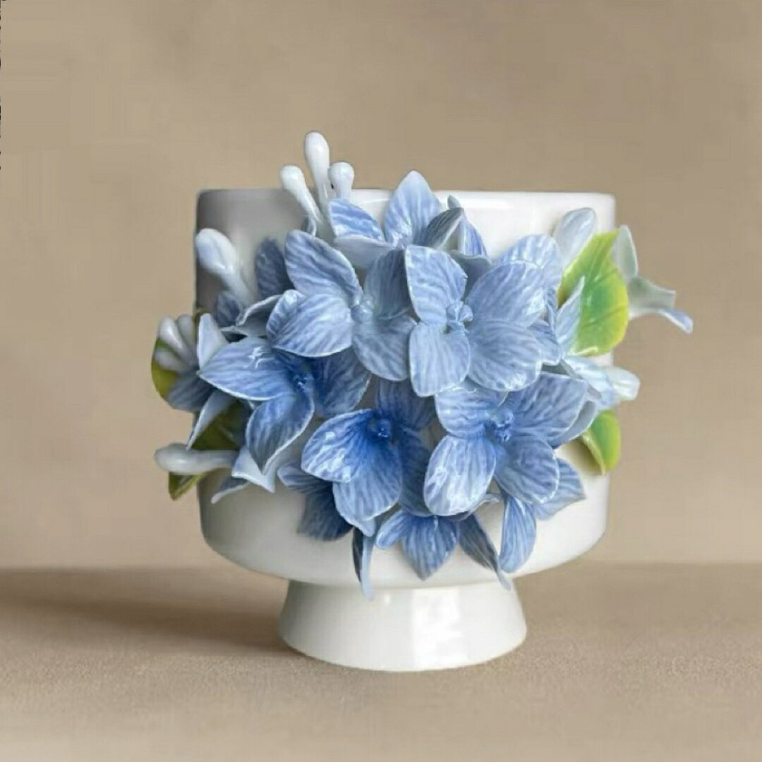 商品説明 立体的なブルーフラワー装飾が美しい、上品な陶器製カップです。繊細な花びらの表現とやさしい色合いが、ティータイムやデザートタイムを華やかに演出します。実用としてはもちろん、インテリアカップとして飾るのもおすすめです。サイズ：高さ：約...