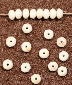 側面がぷっくりふくらんで、ドーナッツのような形をしたファイアーポリッシュビーズのスペイサーです。 チョークホワイトの半面だけに、オーロラ加工（＝ABコーティング）が施されています。さりげなく7色に光るっていうのが、ミソです。 FPドーナッツ...