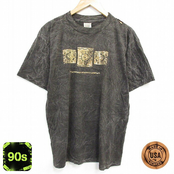 商品紹介90年代のUSA製ビンテージTシャツ。ホピ族の精霊「ココペリ」を大胆に描いたグラフィックと、こげ茶を基調にしたブラウンのタイダイ加工がアメリカンカルチャーの香りを感じさせる一枚です。クルーネックの半袖で、リラックス感のあるメンズXL...