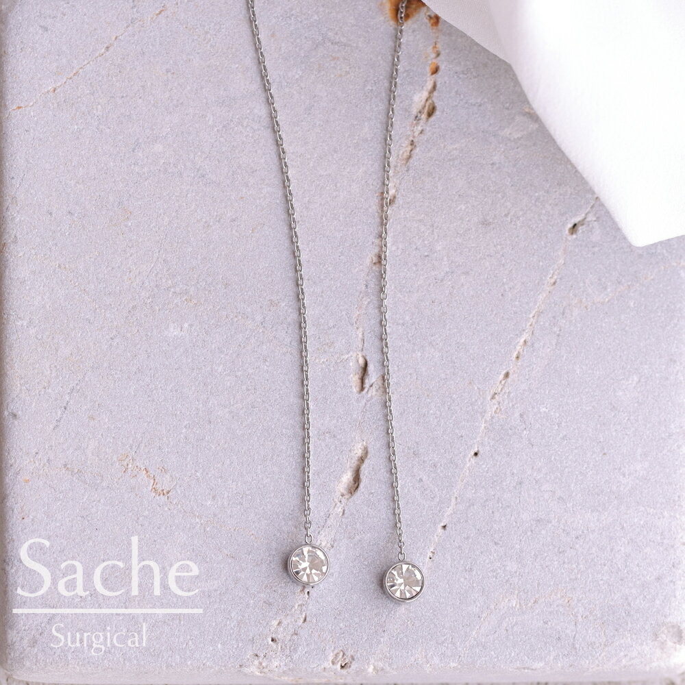 金属アレルギー対応ピアス専門店StienStien（スティーン） ― 縦のラインが、横顔を美しく整えるアメリカンピアス繊細なチェーンの先に、ひと粒のクリスタルが静かにきらめくアメリカンピアス Stien（スティーン）。耳に通して着用するスル...