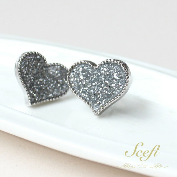 【※】大変申し訳ございませんが、当店ではお客様ご都合による商品交換・返品はお受けしておりません。 シルバーラメが豪華にきらめくハートモチーフピアス。少し立体感のあるハートの内側にラメ樹脂が埋まっています。日常使いにオススメなデザインです。 ...