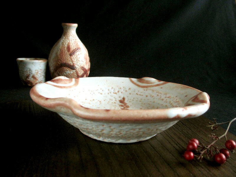 柚子肌に浮かぶ素朴な草文の志野小鉢。優しい肌色の地に長石釉を掛け、鉄釉で描かれた「おもだか」の絵が魅力の小鉢です。風情のある落ち着いた水辺のような爽やかな景色の小鉢を是非ご利用ください。蒔窯でじっくり焼成された穏やかで優しさに満ちた、加藤健...