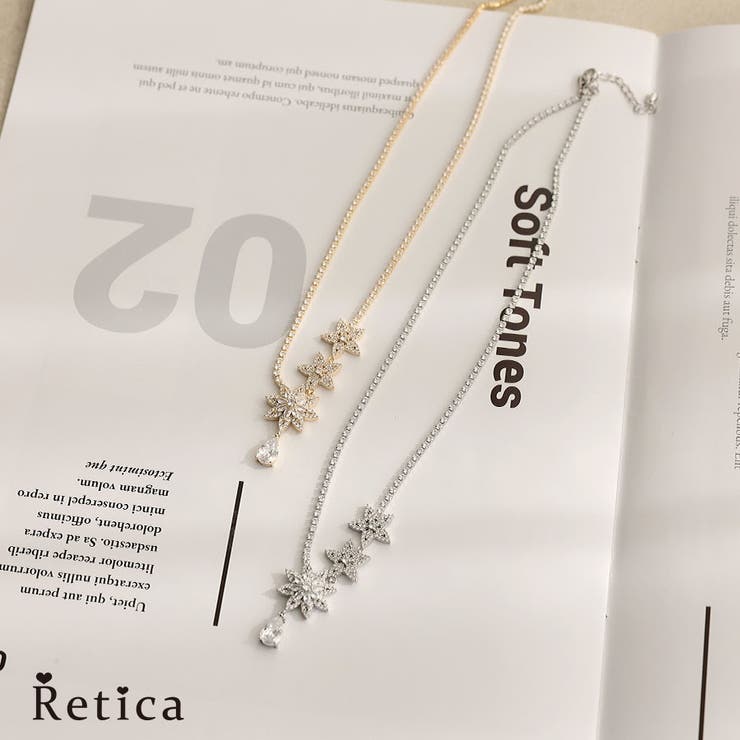 ACCESSORY COLLECTION ITEM デコルテに瞬くようなきらめきを運ぶ、スターモチーフを連ねた高貴なパーティーネックレス。 大きさの異なる星型のビジューと、その先で揺らめくティアドロップ型のストーンが優雅に調和します。 胸元...