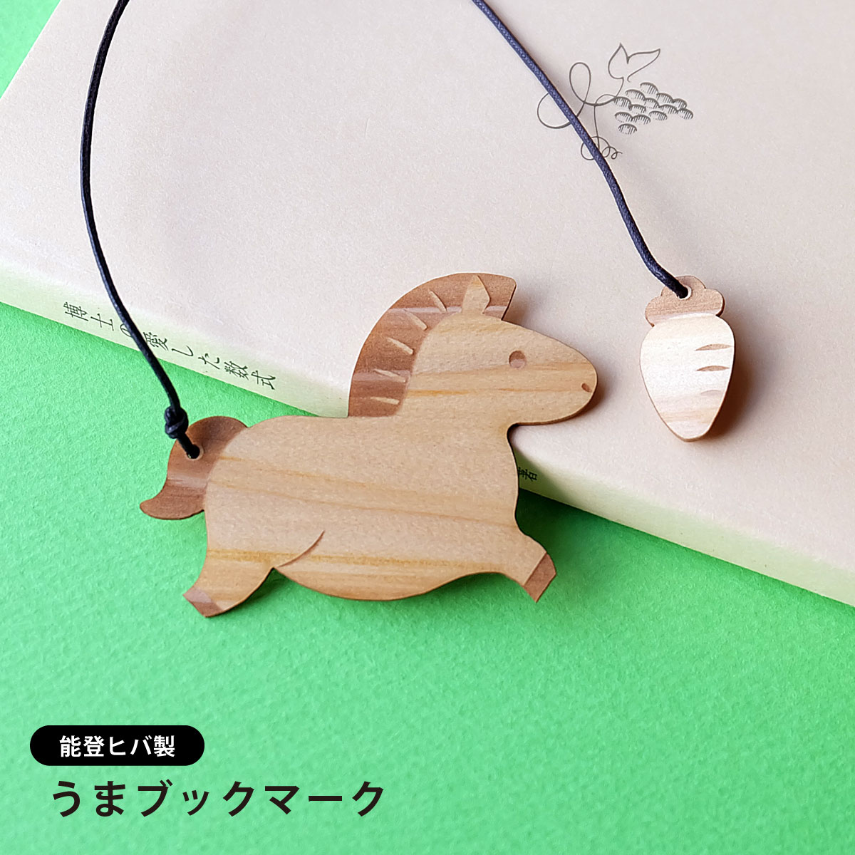 2026年の干支　午をイメージした 「うま」の木製ブックマーク。 木目のぬくもりを感じる石川県の県木「能登ヒバ」にデザインしました。 本に挟めば紐の先についている「にんじん」が本から、ちょっこり頭をだしてくれます。 ※紐のカラーや仕様は予告...