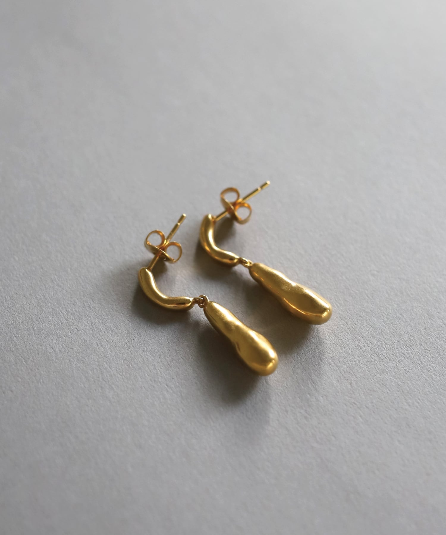 TEN.（テン）ラルムピアス GD朝露が葉の上を流れ落ちる場面から着想を経てデザインに落とし込みました。滴る雫をイメージし、顔周りに動きが出るように2パーツを使用しています。上パーツは耳たぶにフィットするよう優しいカーブを付け、下パーツは動...