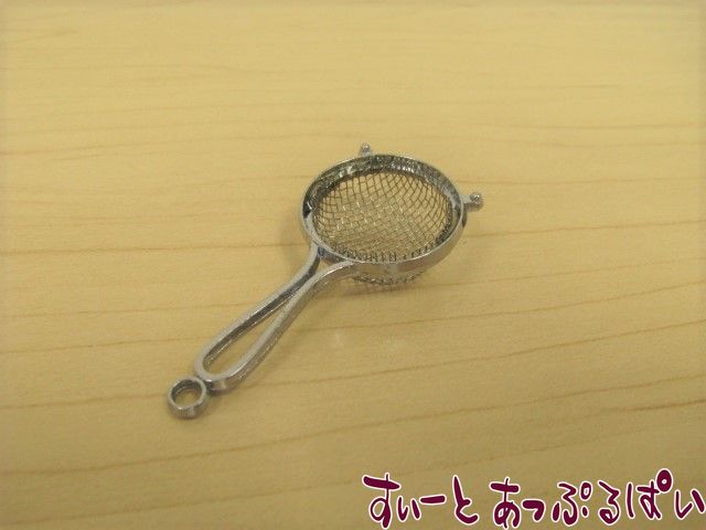 ざるのミニチュアです！当店の「ざる」よりも、一回り大きなザルです。大きさ違いでキッチンに置くのもよさそうですね！金属製です。ぜひあなたのドールハウスに！長さ約42ミリ。ザル部分の直径約18ミリ。