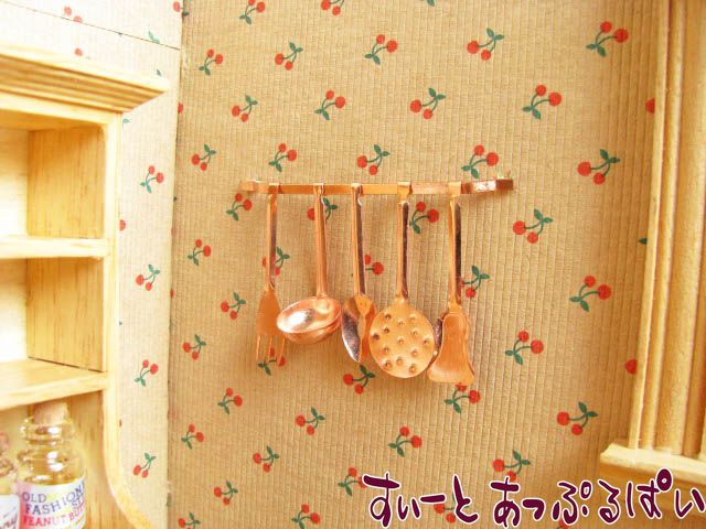 調理道具のセットです。壁に掛けられるよう、ハンガーもセットになっています。（ハンガーは壁に接着してご利用ください）貴方のドールハウスに、ぜひお役立てください！金属製。サイズ：ハンガーの長さ約60ミリ、おたまの長さ約30ミリ。