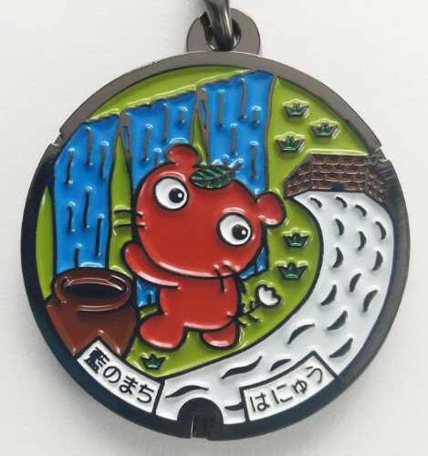 羽生市のキャラクター「ムジナもん」が、中川の岸辺で藍染をしている姿を描いた可愛いマンホール蓋です。 サイズ：径35mm 材　質：亜鉛合金