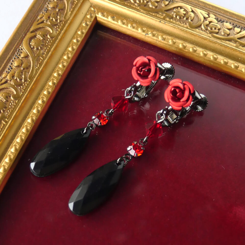 「ローズガーデン」シリーズより、深紅の薔薇が妖しく咲き誇るゴシックイヤリング。 センターには美しく咲く赤薔薇をあしらい、その下には漆黒のドロップパーツを組み合わせました。歩くたびに優雅に揺れ、耳元に幻想的な存在感を演出します。 薔薇とドロッ...