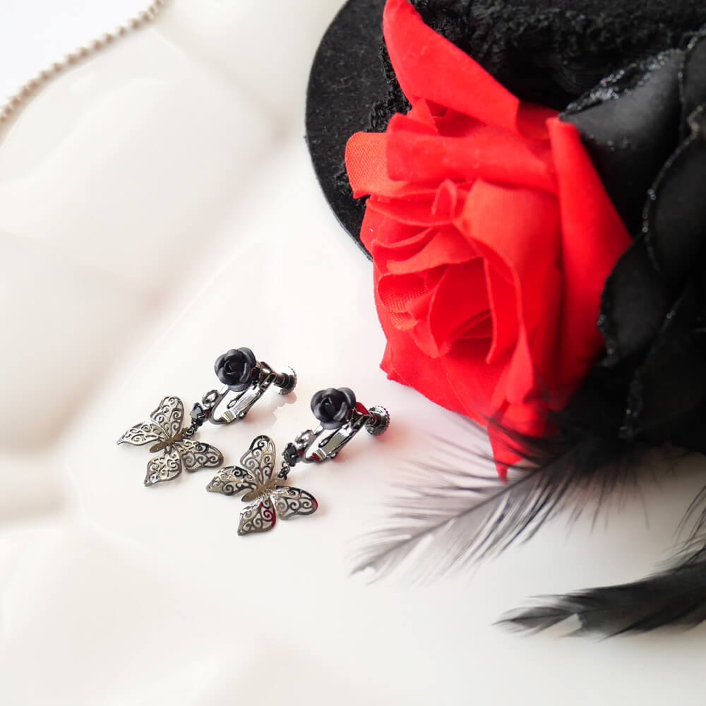 【控えめゴスロリ シリーズ】 サイズは2.5センチと小さめですが、薔薇と蝶のゴスロリモチーフが特徴的 繊細なステンド蝶のミニパーツが美しく、控えめなゴスロリテイストを楽しむことができるイヤリングです。 ピアスホールがなくても装着可能なので、...