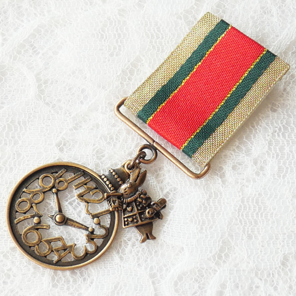 【セレクトブローチ】 時計モチーフにトランプラビット アリステイストの勲章 お洋服やバックにつけて コーディネートのバリエーションがアップ！ 【サイズ】 　約：縦7.8センチ×横3センチ 【材質】 キャスト合金、リボン韓国製