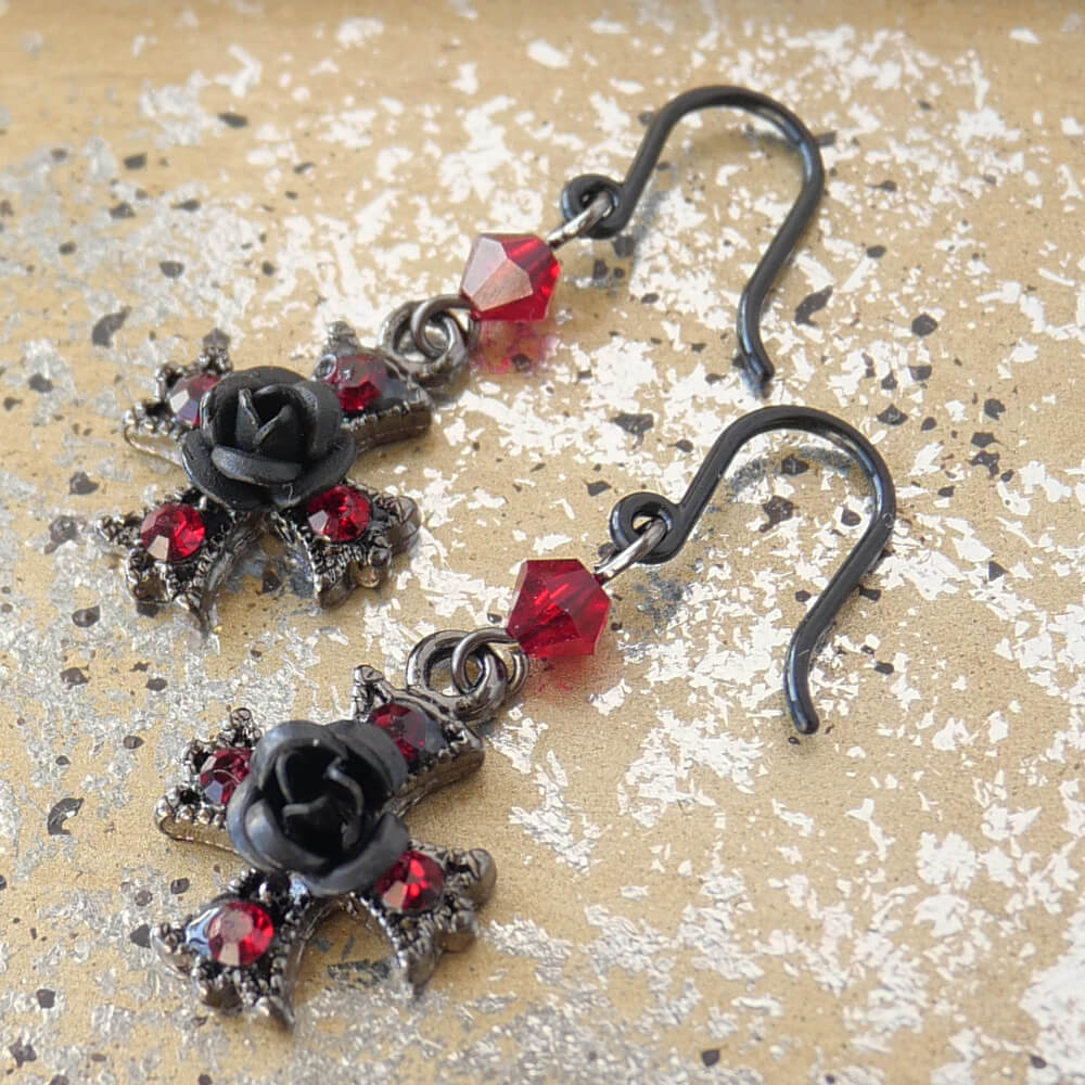 小さな十字パーツに4つの赤いストーン その中央に黒薔薇のデザインのミニピアス 普段使いOKの幅広いスタイルに合わせられるゴスロリテイスト 樹脂フックパーツを使用しているため、金属アレルギーの方にも安心してお使いいただけます。 レッドストーン...