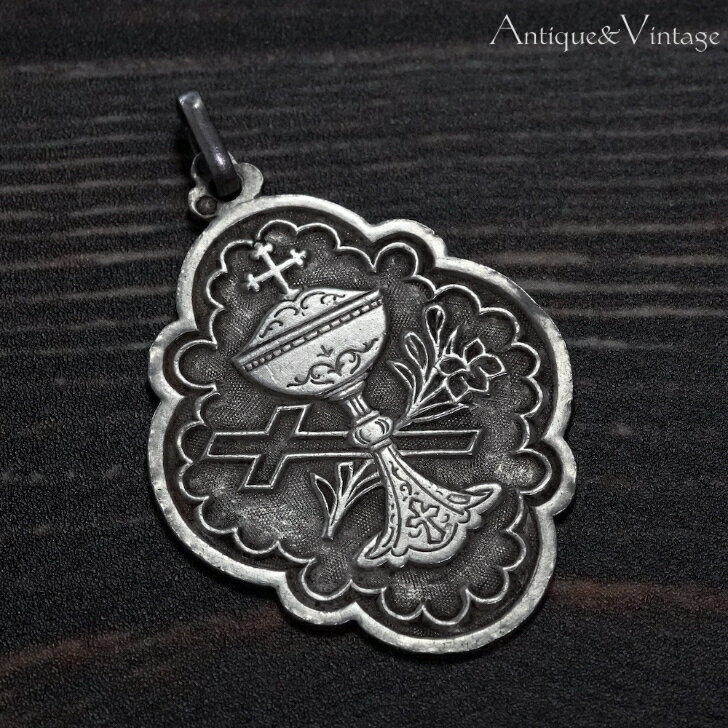 聖体拝領のアンティークシルバーメダイです。カテゴリー：アンティーク＆ヴィンテージ製造国：フランス製造年：ーカラー：シルバー素材：シルバー800以上（刻印あり）サイズ：縦約3.55(3.1)cm×横約2.6cmカン・バチカン：カン付属状態 ※...