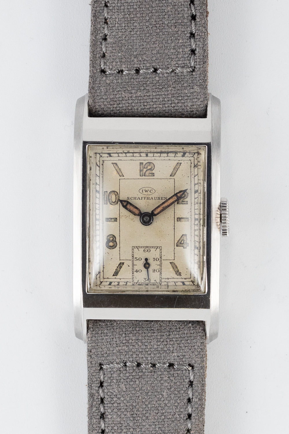 COMMENT 旧ロゴのIWC、レクタンギュラーモデルです。滑らかな着用感を可能にする腕に沿うように湾曲したケースには、トノー型ムーブメントCal.87が搭載されています。ダイヤルはホワイトで、飛びアラビアのインデックスはルミナス、ブルース...