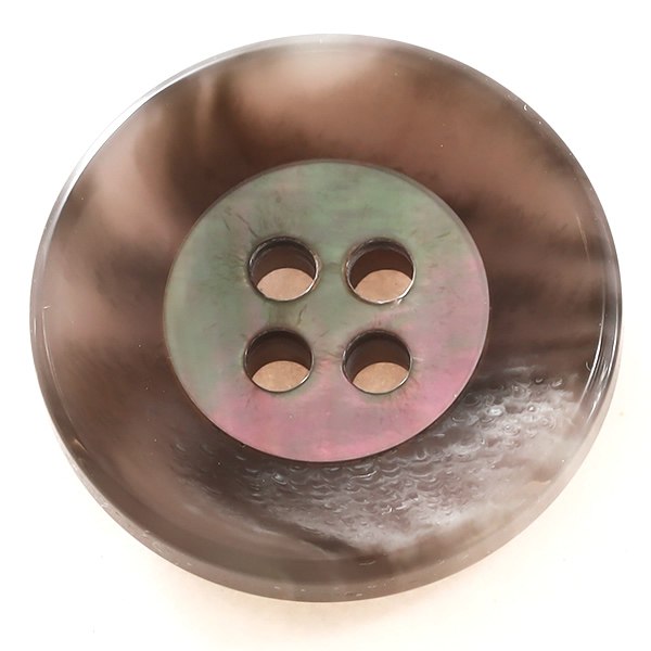 素材 ポリエステル,黒蝶貝 サイズ 20mm 特徴 外側は透明感と光沢のある樹脂で内側は天然の黒蝶貝を使った練りボタンのはめ込みボタンです。 ですので、貝だけの派手さも抑えてポリエステルの落ち着いた雰囲気を合わせた高級感が高く、人気のボタン...