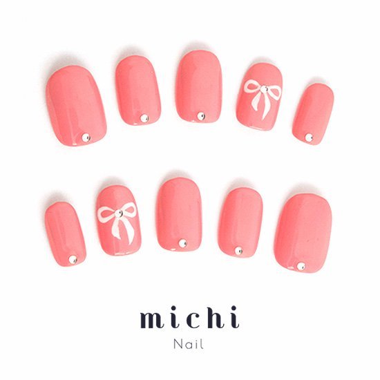 [商品説明]コーラルピンクに白のリボンを描きました。クリスタルのストーンを一粒ずつ置き、大人可愛いネイルに仕上げました。