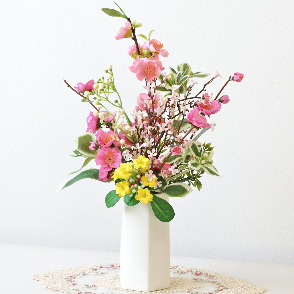 シンプルなホワイトの陶器に、桃の花や春の小花が満開のアレンジです。 サイズ：約高さ35cm×幅23cm×奥行17cm＊商品の仕様は変更になる場合がございます＊受注制作のため数日お時間をいただく場合がございます シルクフラワーとは、シルクの様...