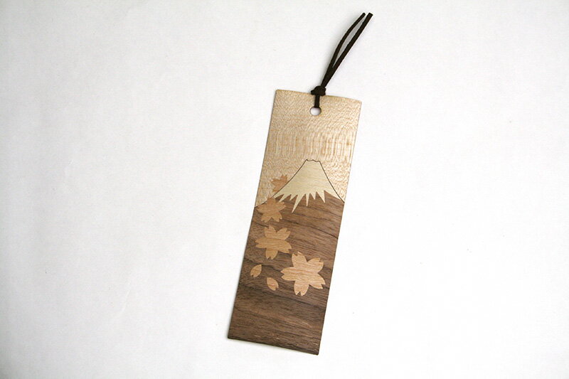 箱根寄木細工のズクを使ったしおりです。手作りのため大きさ・模様・ひもの色が異なる場合があります。 サイズ：約150x50 mm 【備考】天然の素材を用いた手作り品のため、色・柄・大きさはホームページ上の写真や表記と異なる場合がございます。