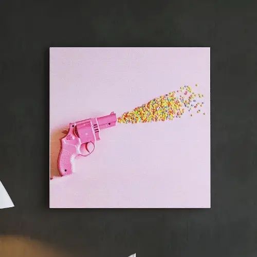 お客様の注目キーワードはこちら！ポップでかわいいデザインに元気が出る モダンアートのウォールデコピンク色の拳銃がデザインされた、存在感抜群のアートパネルでお部屋を飾ってみませんか。薄ピンクの背景に置かれたピンクの拳銃からカラフルなビーズが飛...